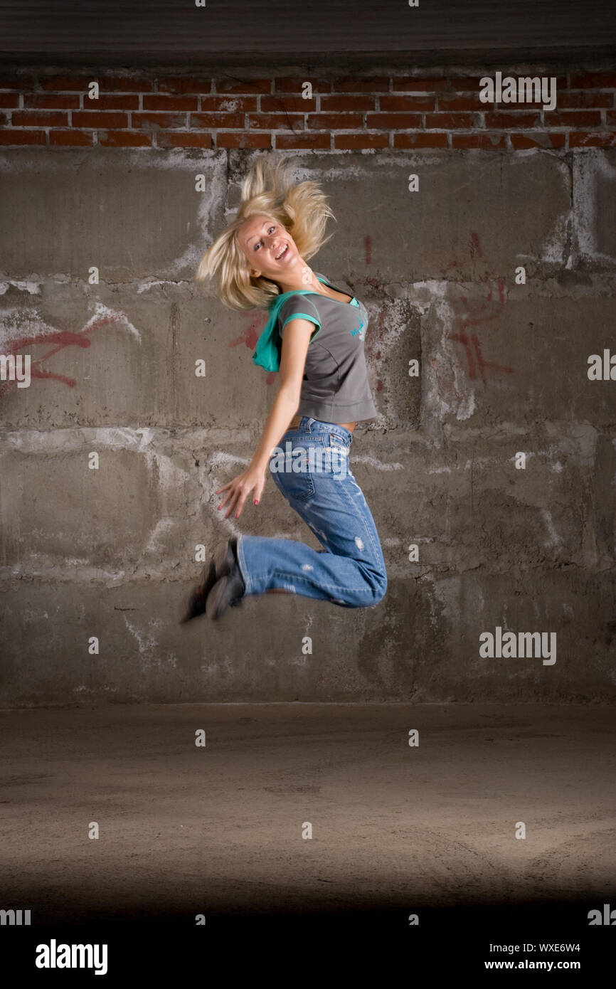 Beautiful hip hop girl dancing over grey brick wall Stock Photo - Alamy
