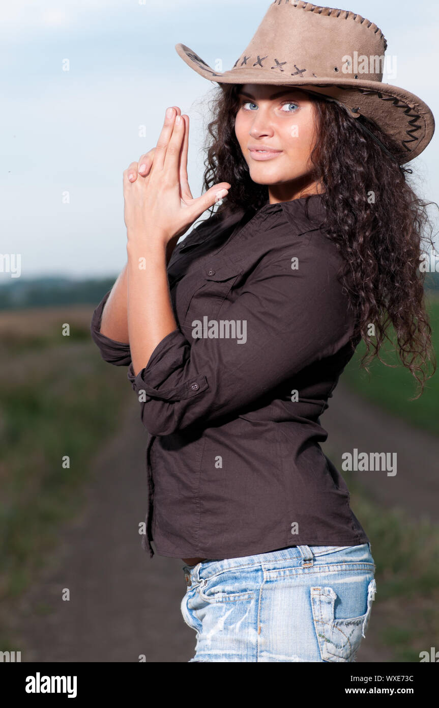Beautiful cowboy woman with perfect hair and skin posing in country ...