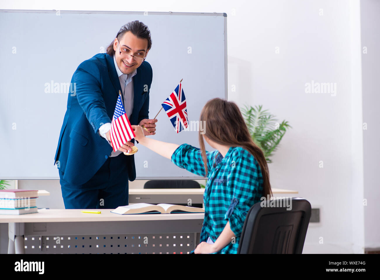 Male english teacher and female student in the classroom Stock Photo ...