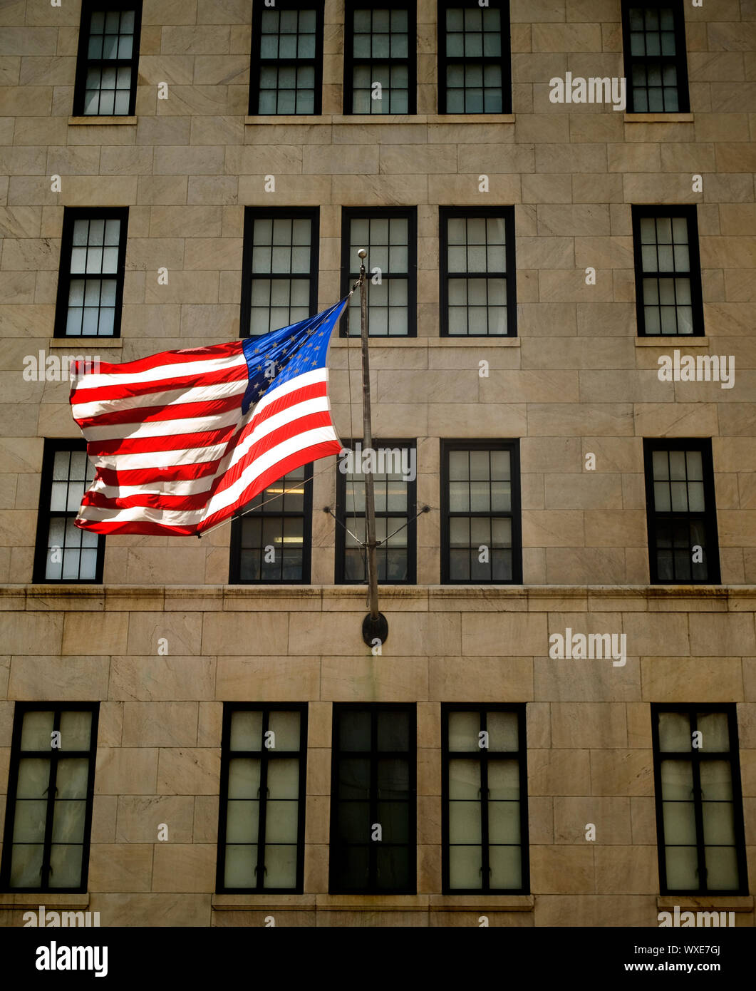 An American flag waving on the facade of a public building Stock Photo ...
