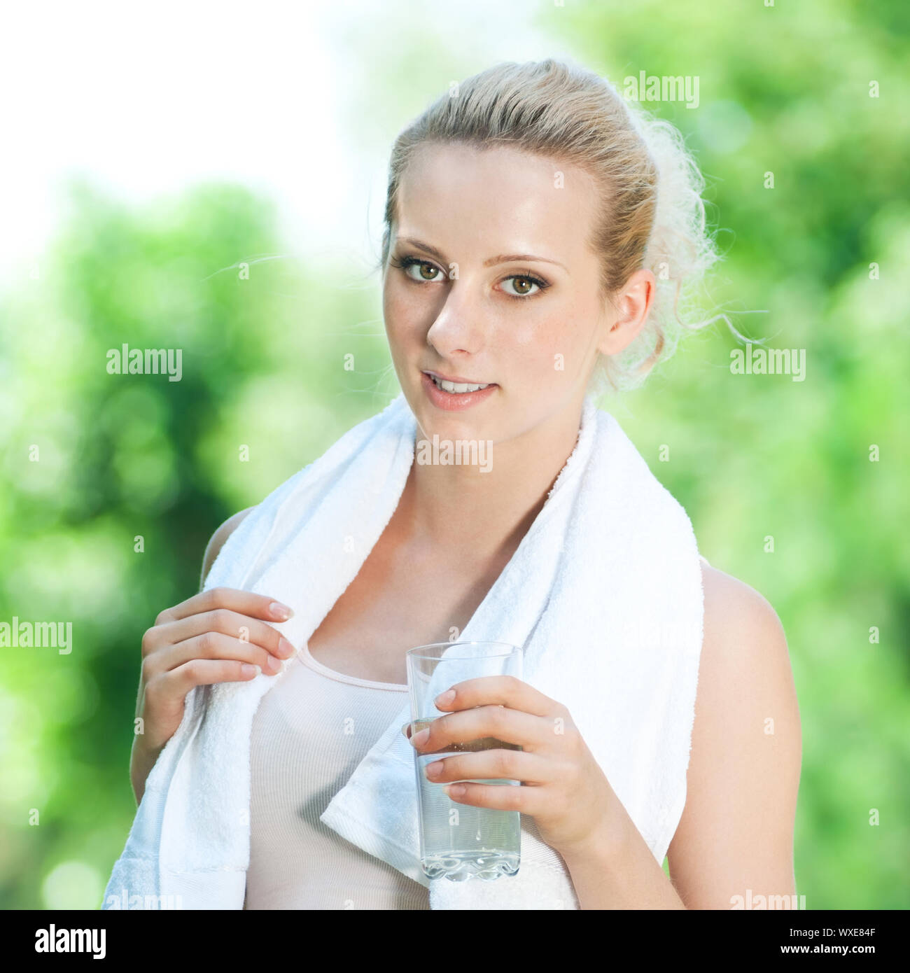 Young woman drinking water after fitness exercise Stock Photo - Alamy
