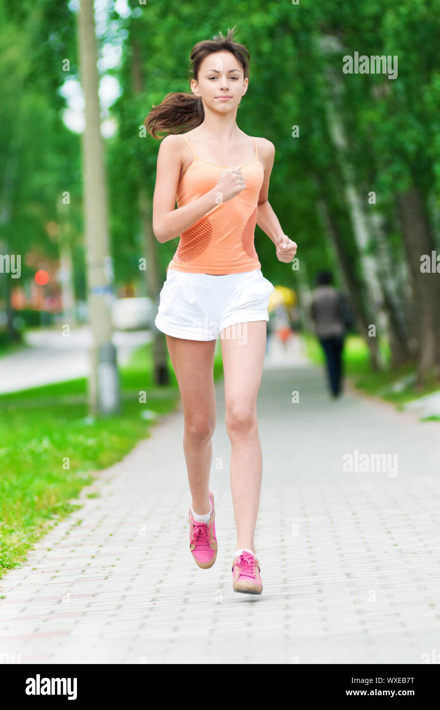 Beautiful teenage sport girl running on the grass active hi-res stock ...