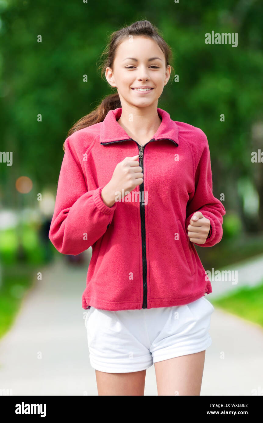 Beautiful teenage girl running in green park on sunny summer day Stock ...
