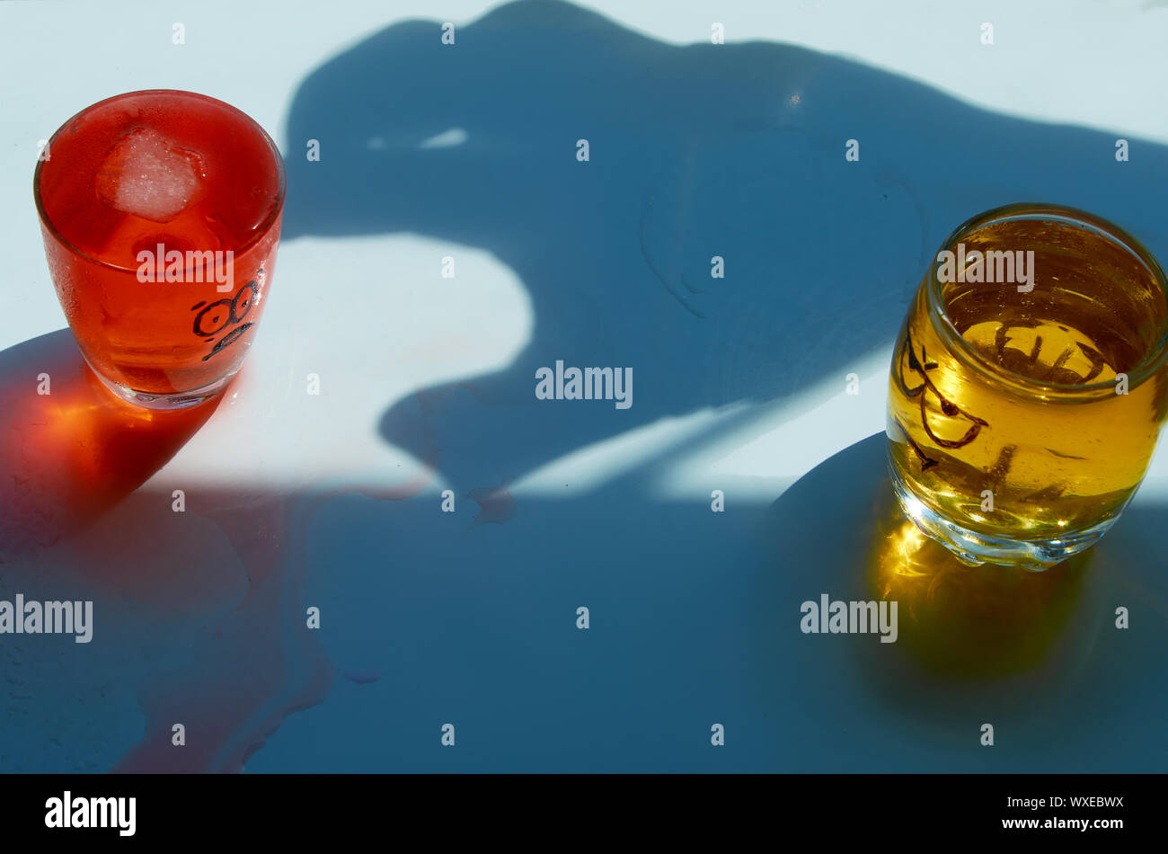 Glasses of alcohol with painted emotions and shadows Stock Photo - Alamy