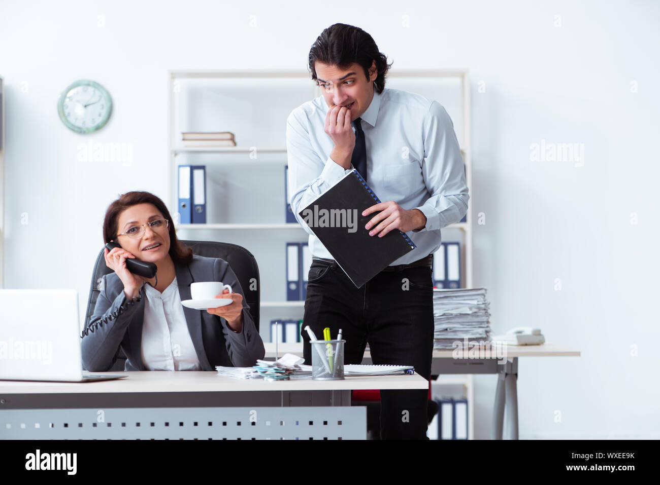 Old female boss and young male employee in the office Stock Photo - Alamy