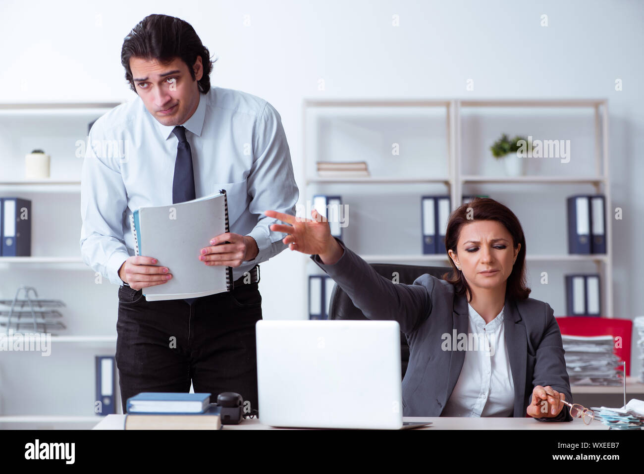 Old female boss and young male employee in the office Stock Photo - Alamy