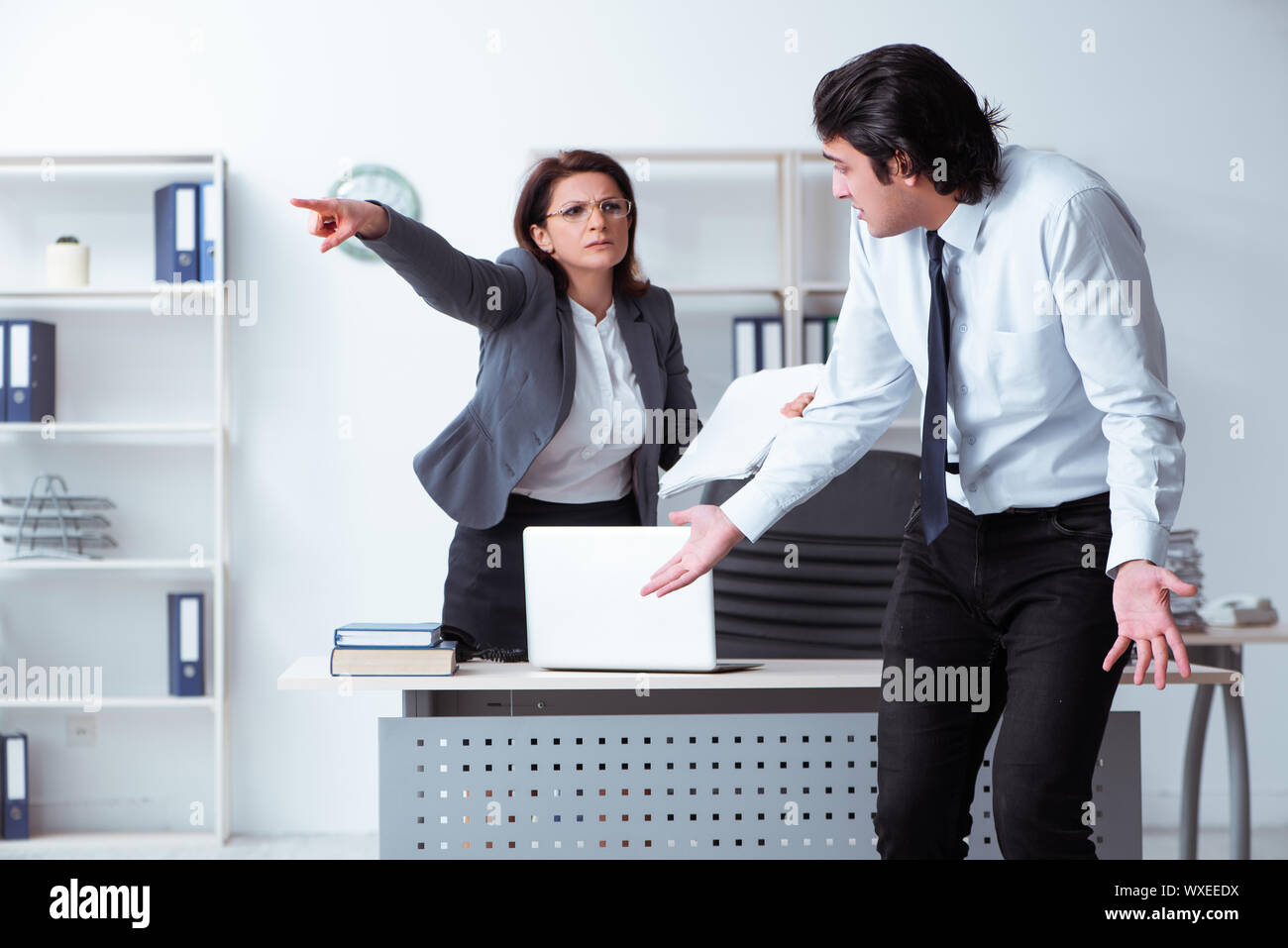 Old female boss and young male employee in the office Stock Photo - Alamy