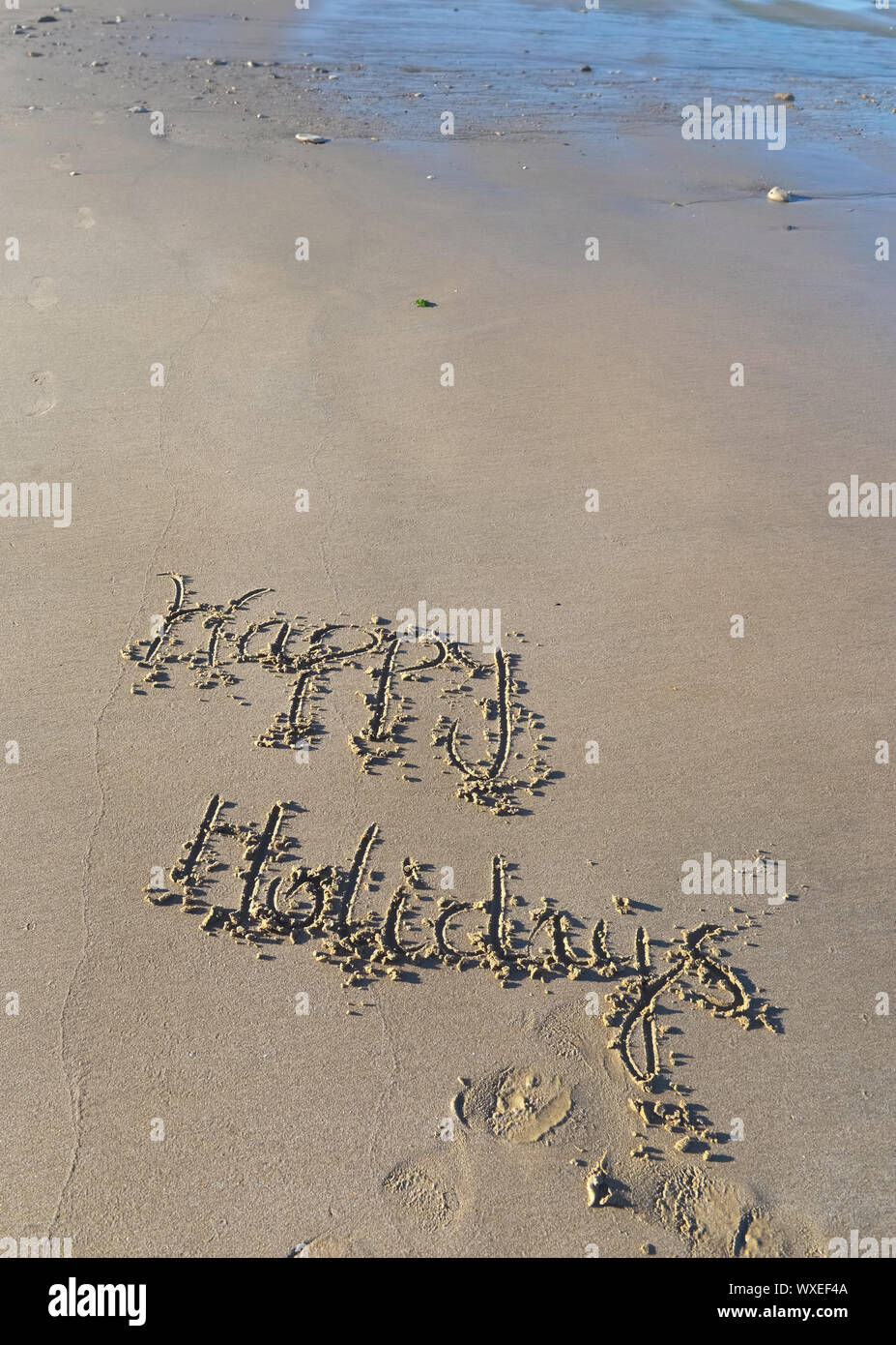 happy holiday hand written on the sand in the beach Stock Photo - Alamy