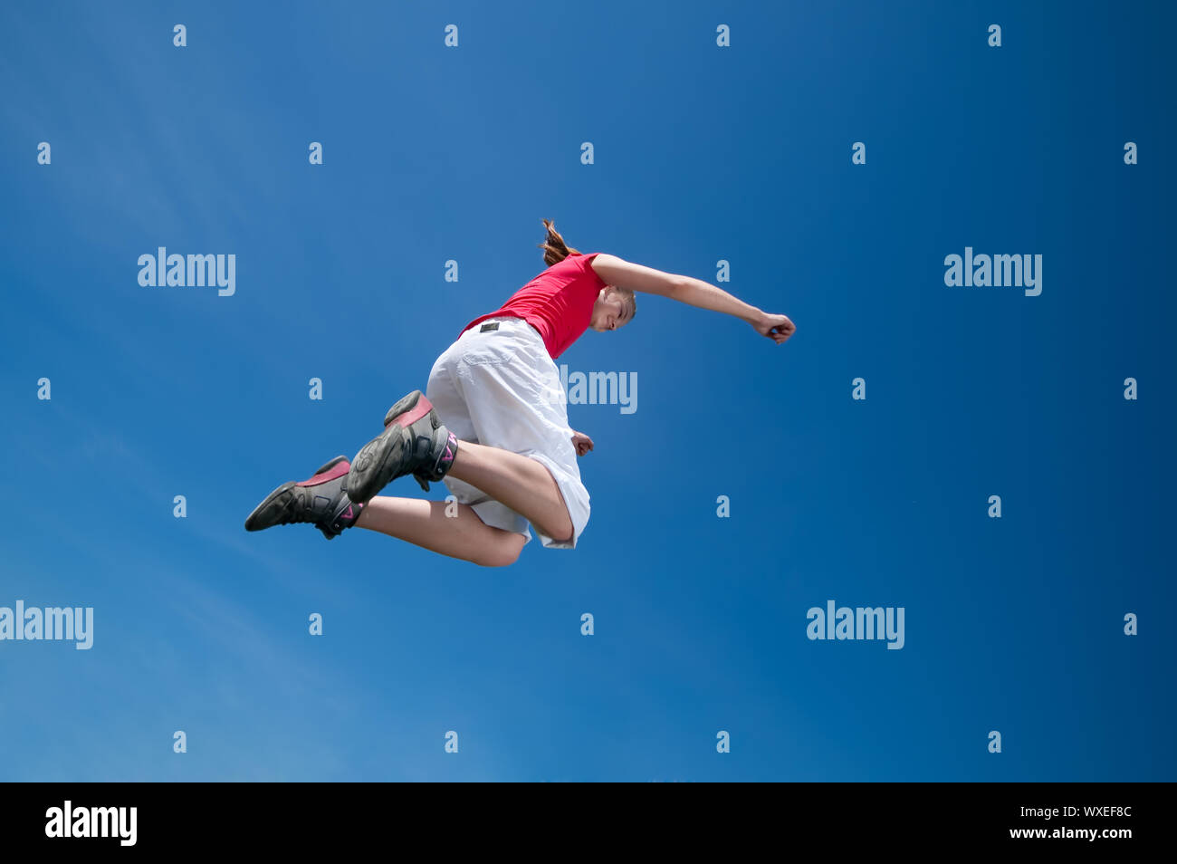 Beautiful young woman jump into blue sky on sunny summer day Stock ...