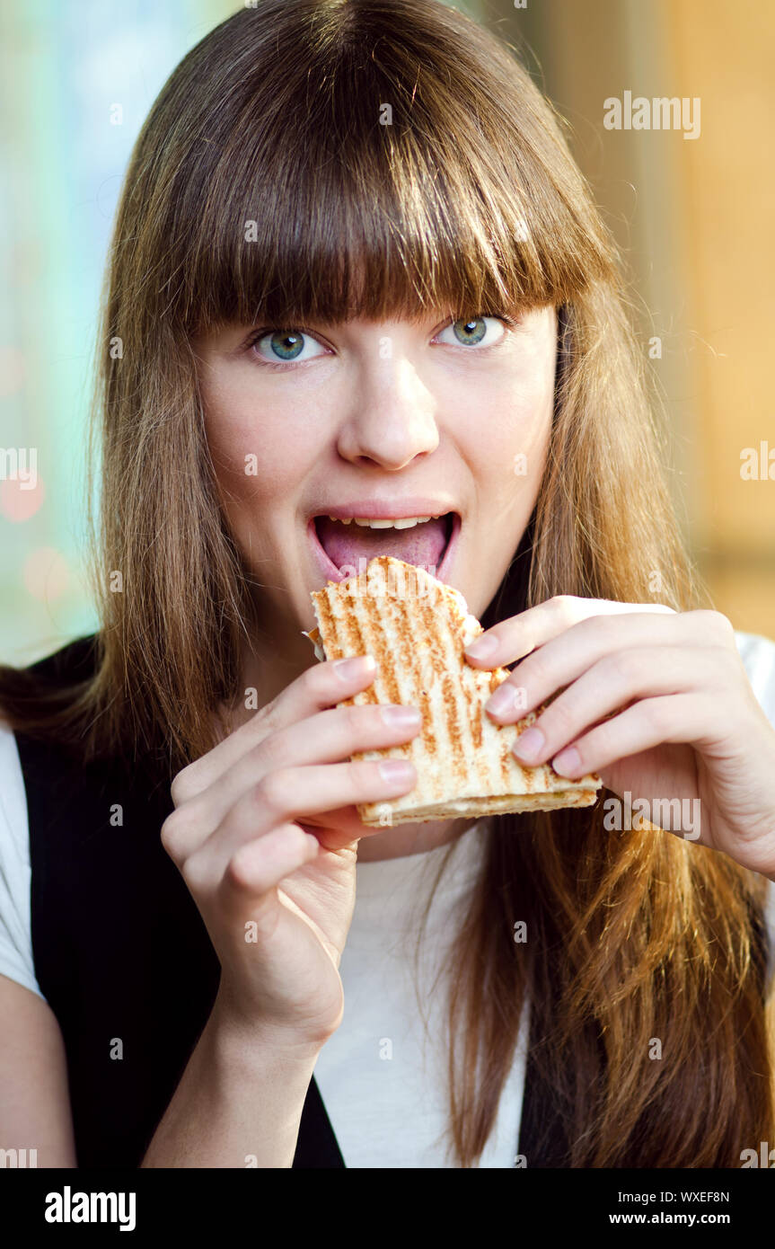 Portrait of young happy woman with sandwich at cafe Stock Photo - Alamy