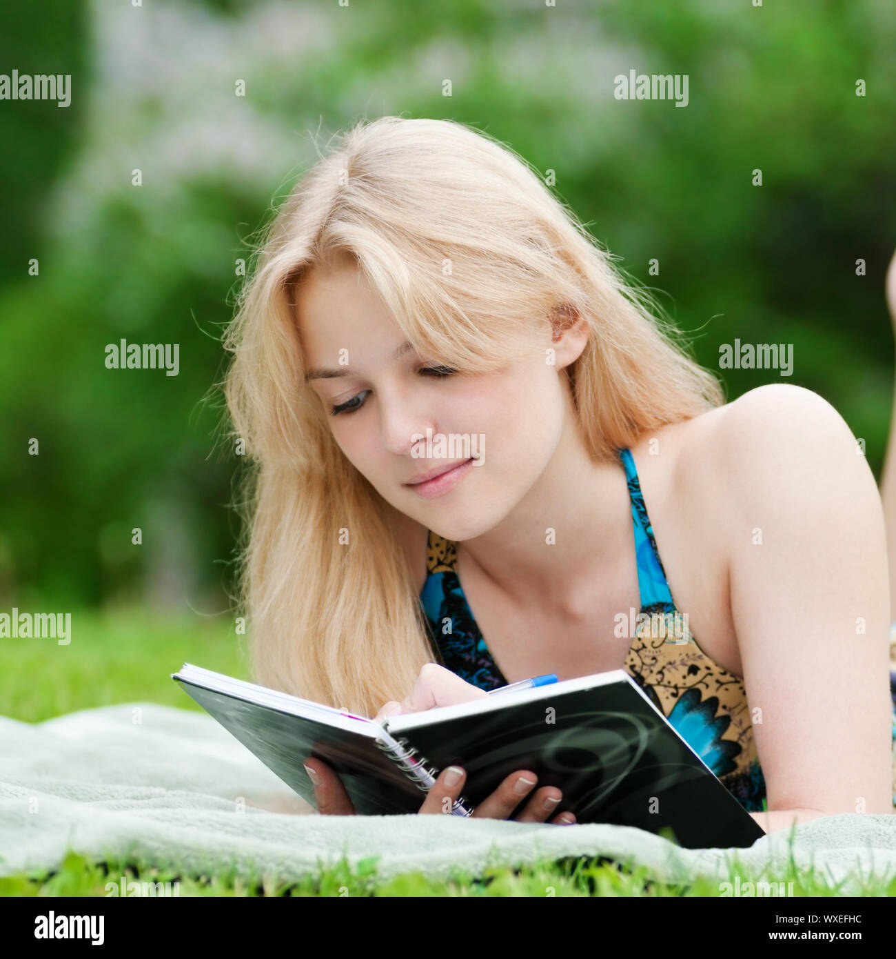 Beautiful young woman read book, at green summer park Stock Photo - Alamy