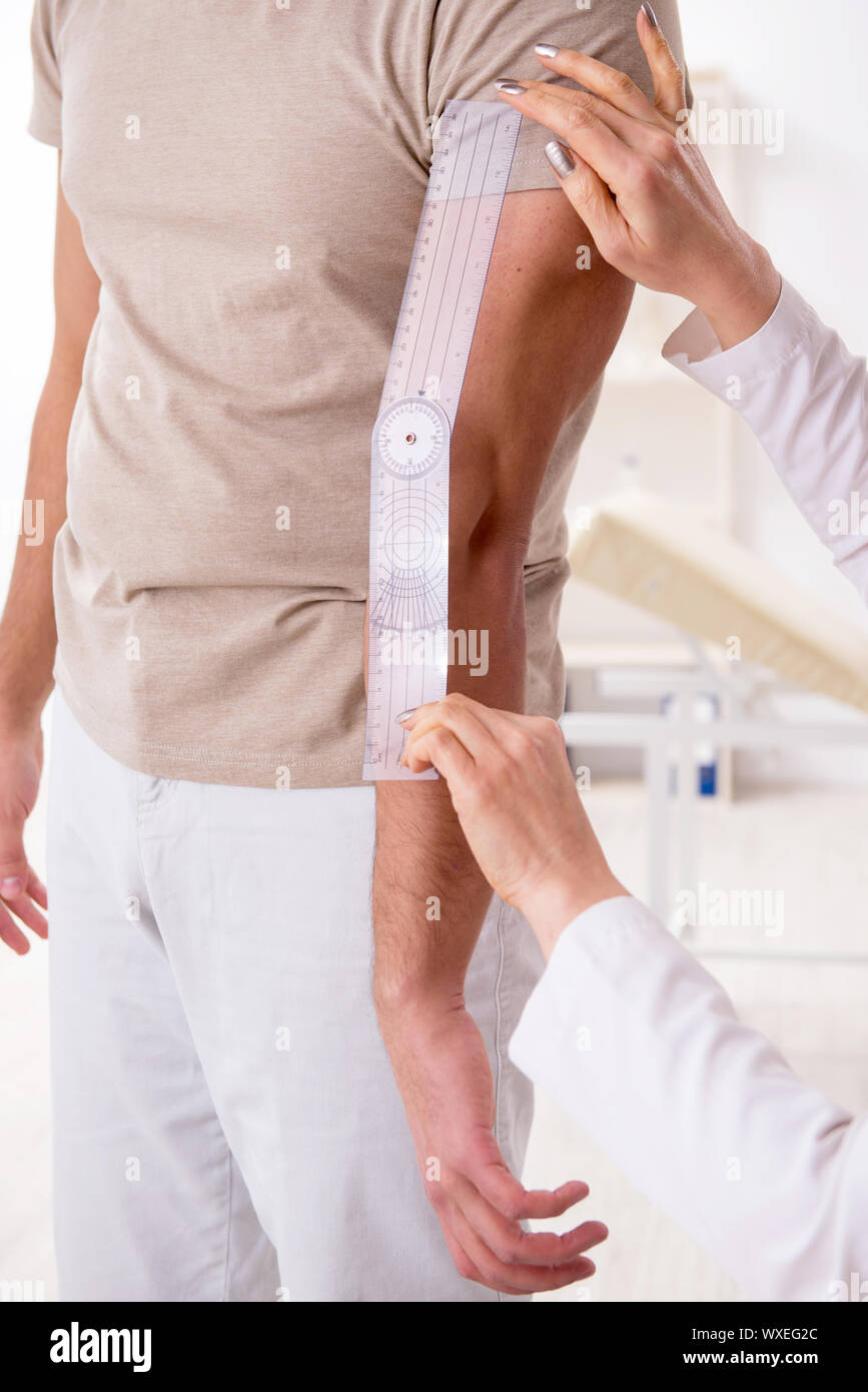 Female doctor checking patient's joint flexibility with goniometer ...