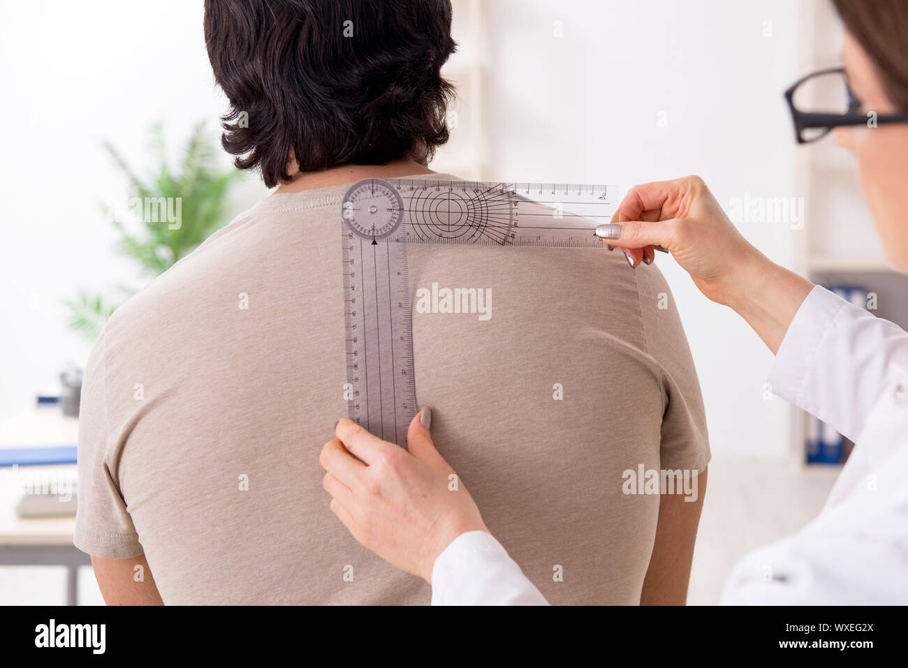 Female doctor checking patient's joint flexibility with goniometer ...
