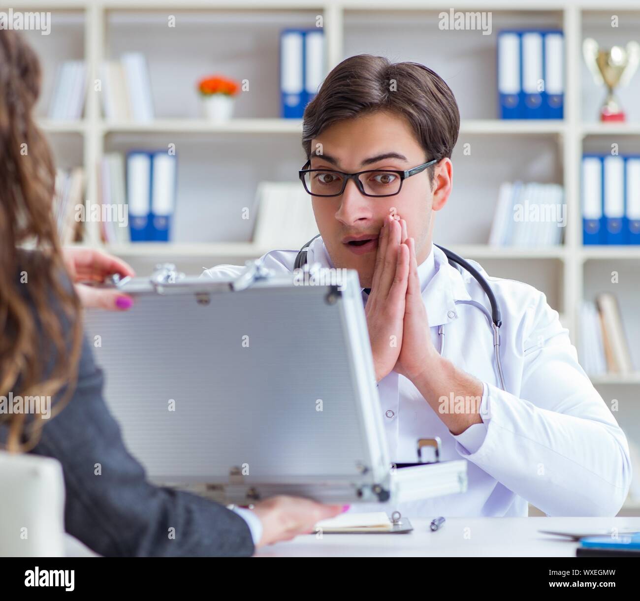 Young doctor in medical insurance fraud concept Stock Photo - Alamy