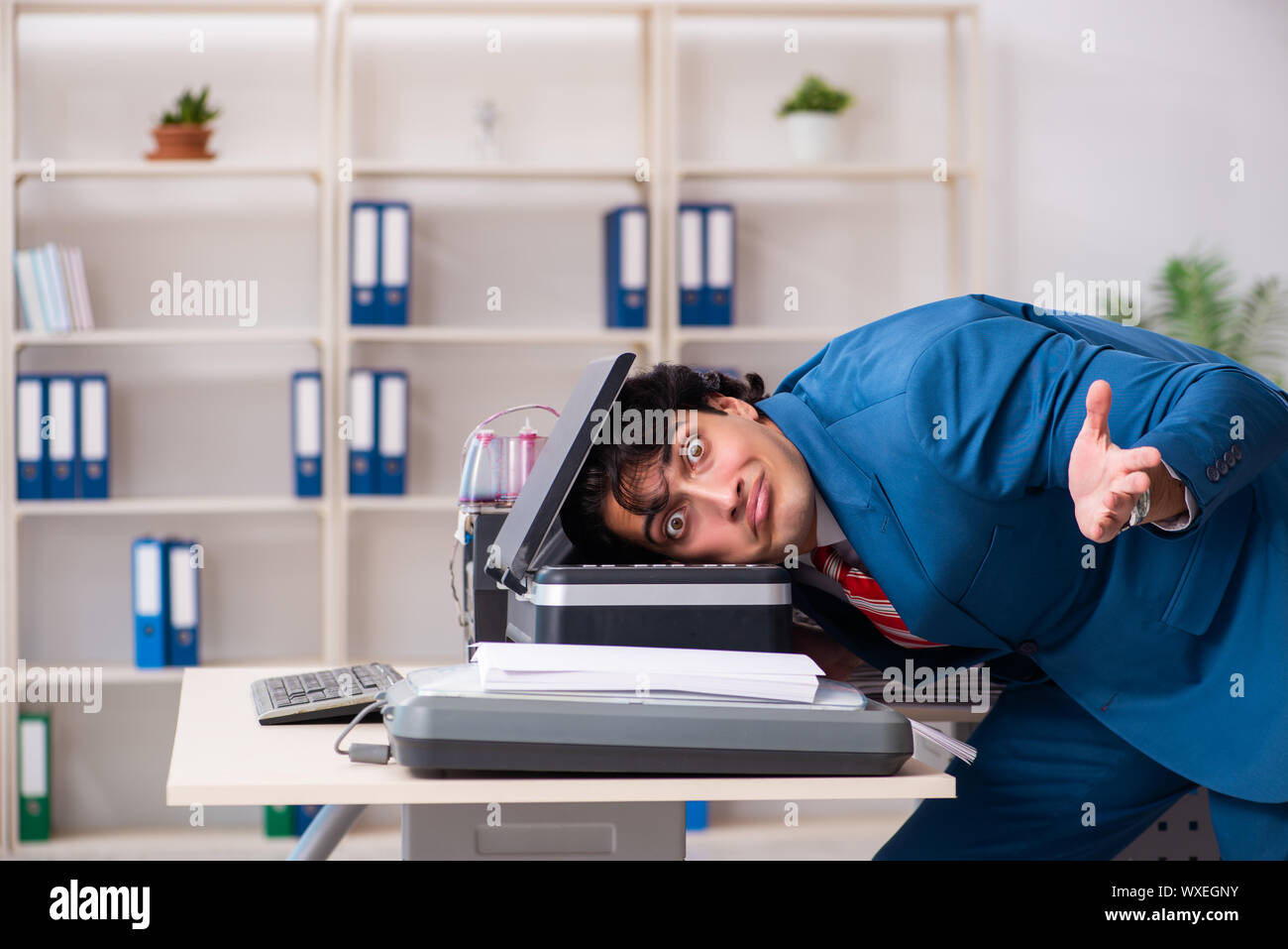 Young employee making copies at copying machine Stock Photo - Alamy