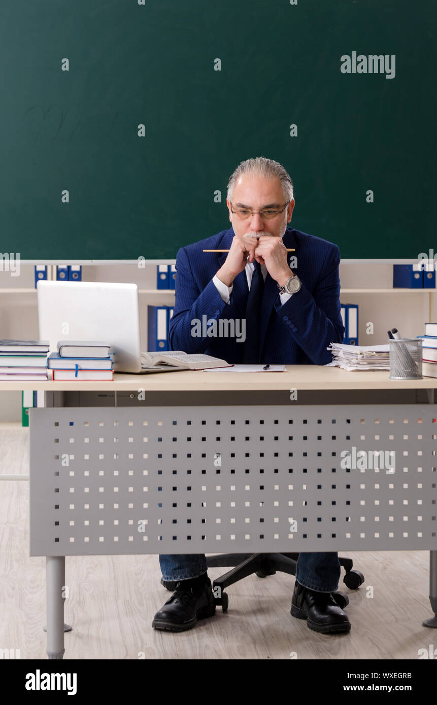 Aged male teacher in front of chalkboard Stock Photo - Alamy