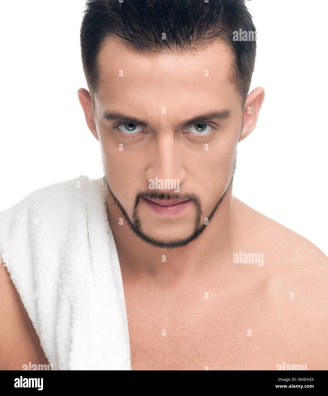 Close up portrait of young angry man face with perfect skin and towel ...