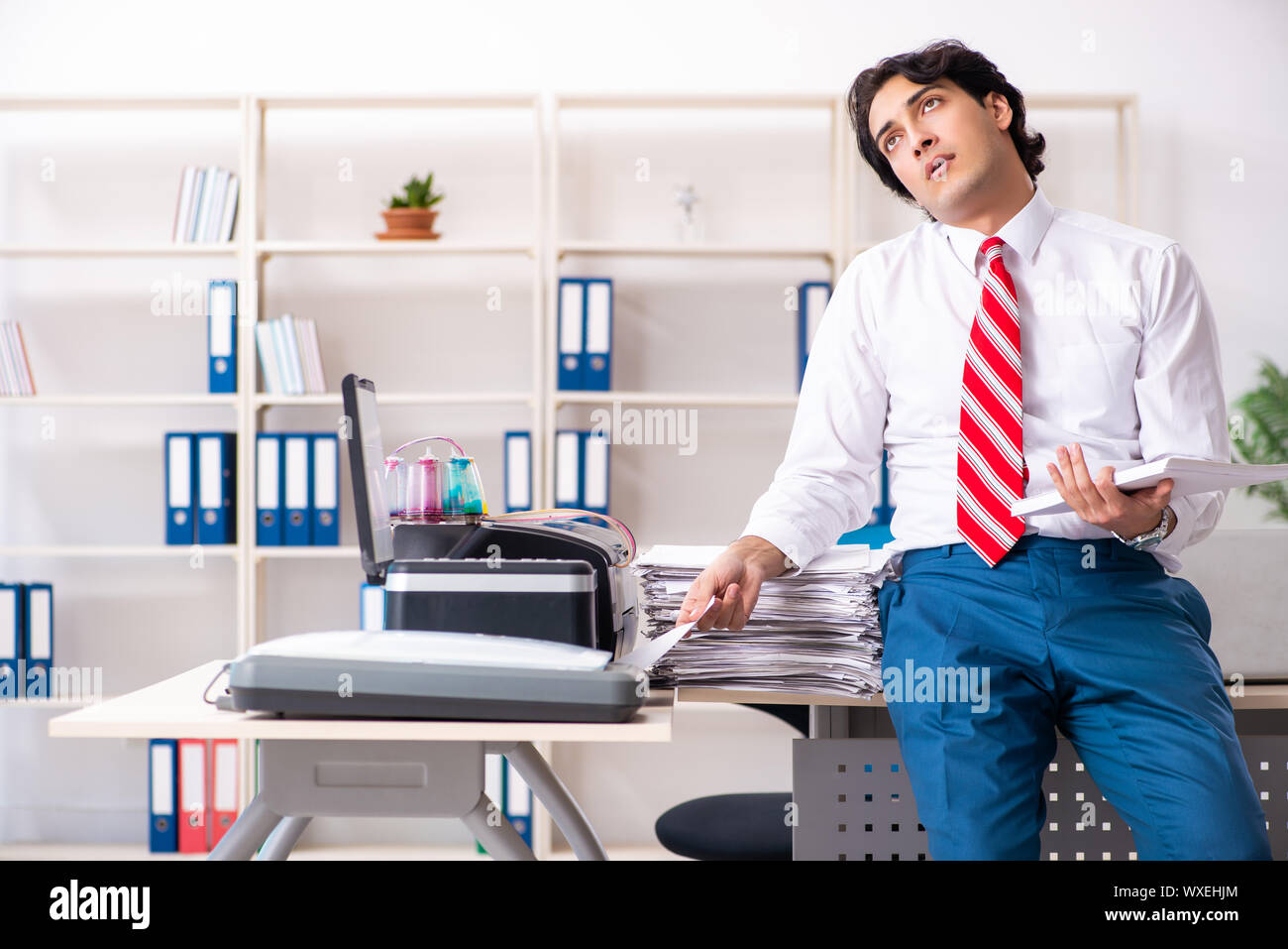 Young employee making copies at copying machine Stock Photo - Alamy