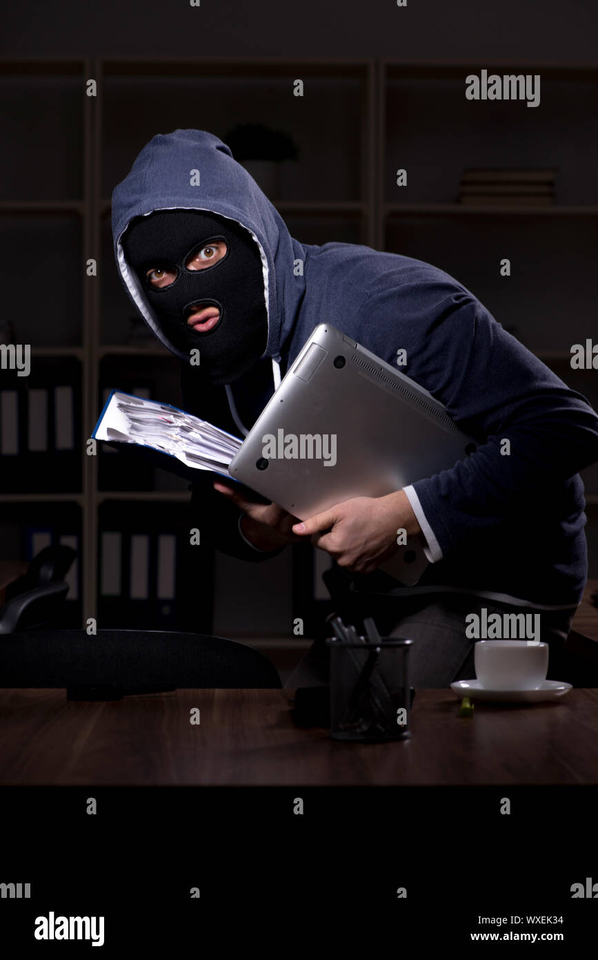 Male thief in balaclava in the office night time Stock Photo - Alamy
