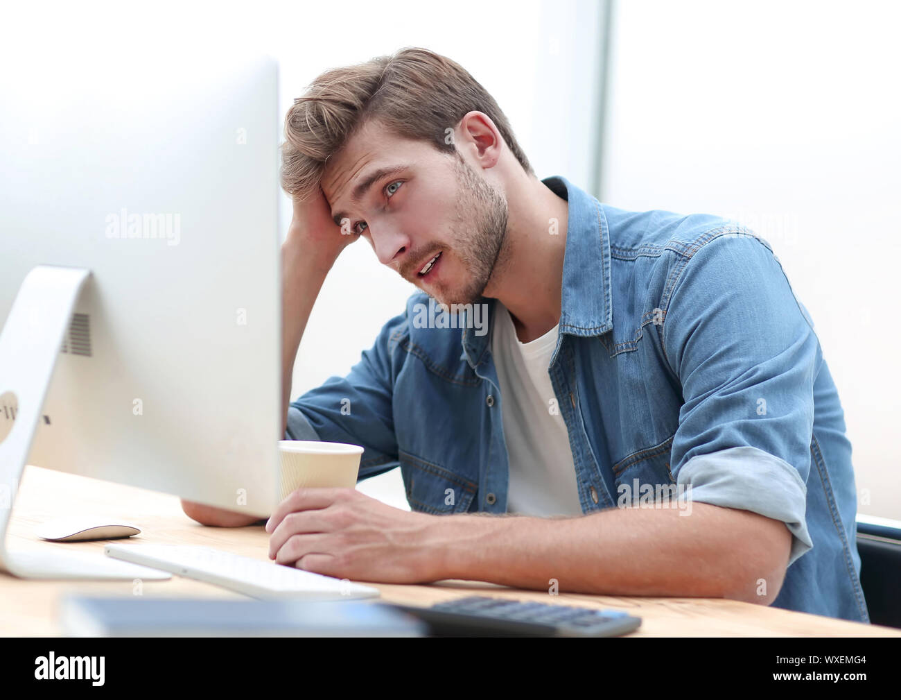 sad businessman with a coffee Cup looking at his computer monitor Stock ...