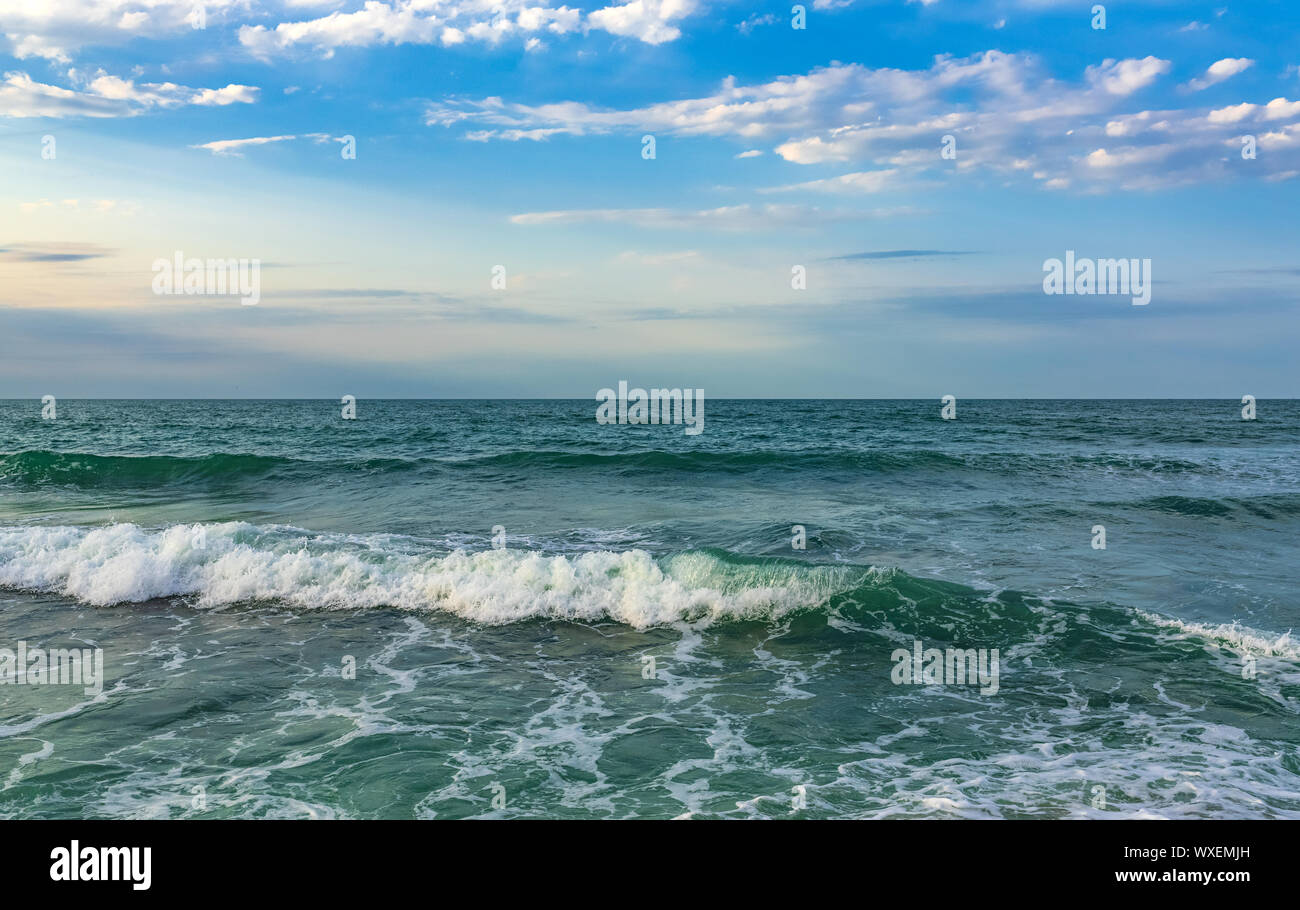 Beach with a wavy beautiful sea Stock Photo - Alamy
