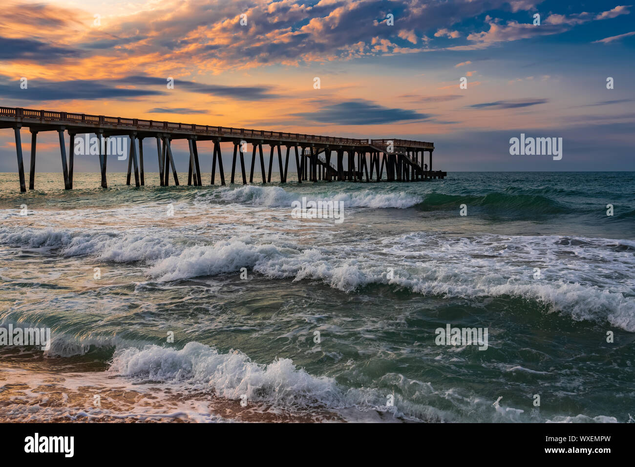 Pier at sunset, wavy beautiful sea Stock Photo - Alamy