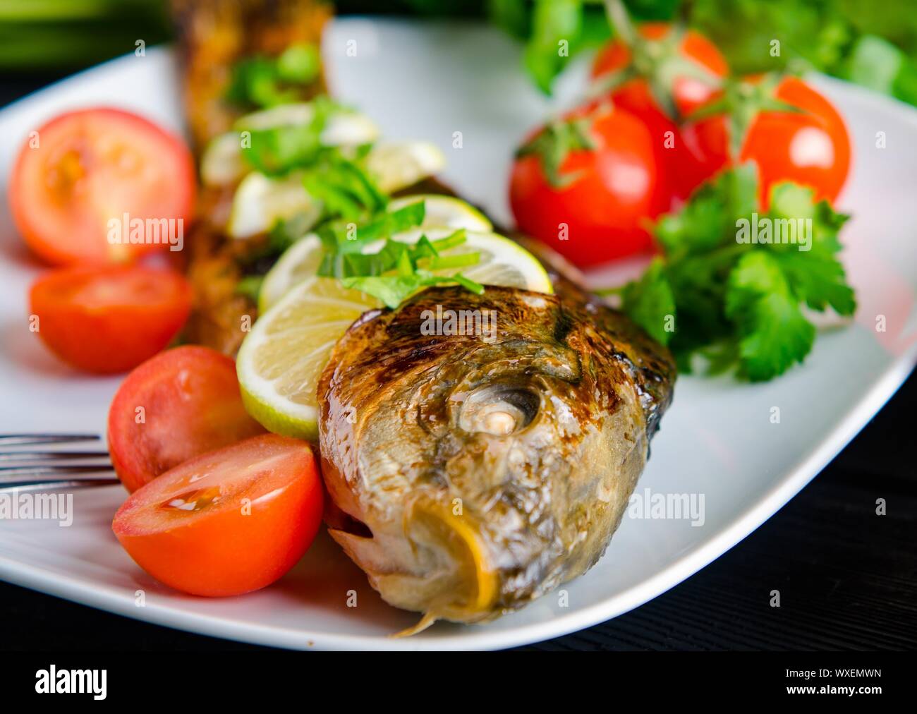 Fried fish served on the plate Stock Photo - Alamy