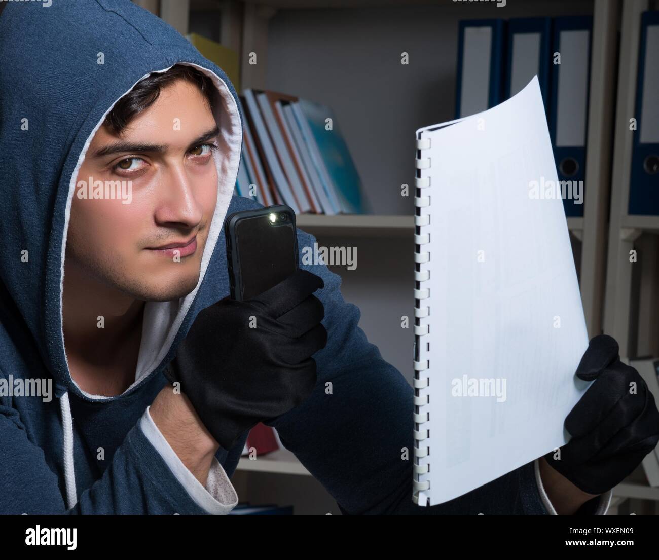 Young man in industrial espionage concept Stock Photo - Alamy