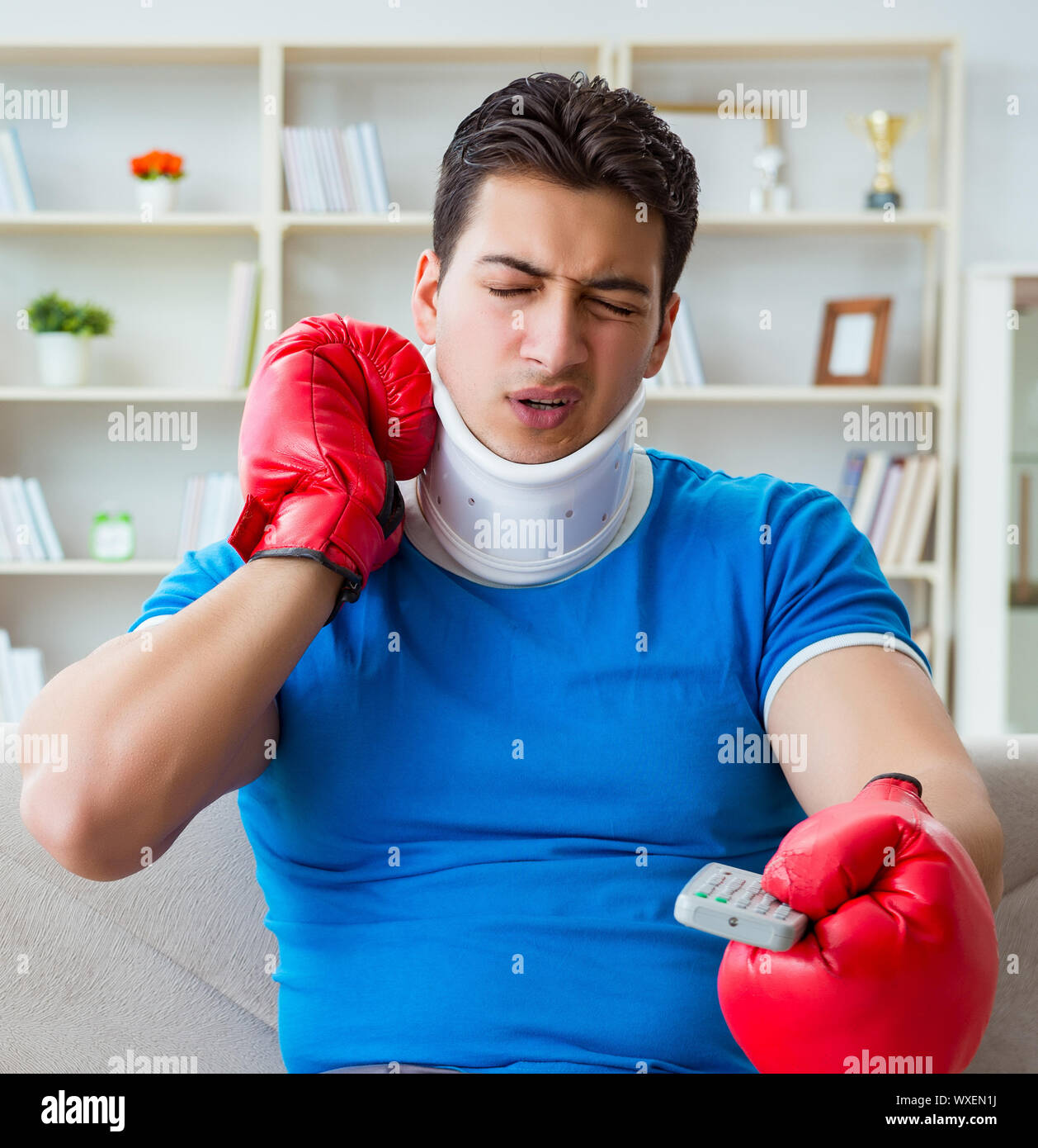 Man with neck injury watching boxing at home Stock Photo - Alamy
