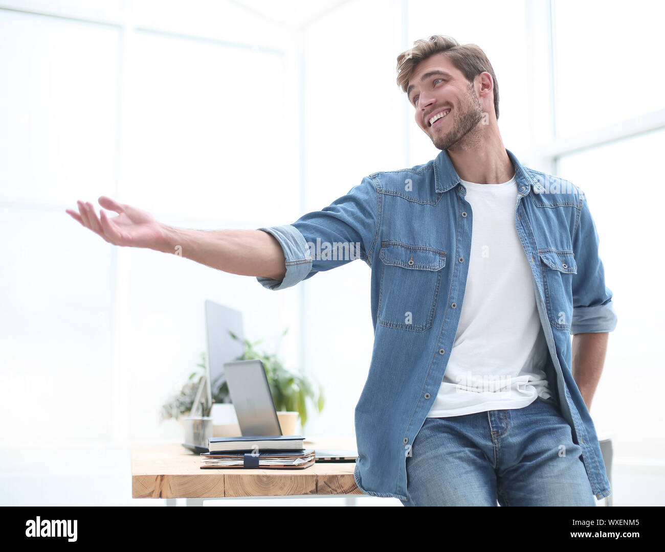 friendly young entrepreneur inviting to his office Stock Photo - Alamy