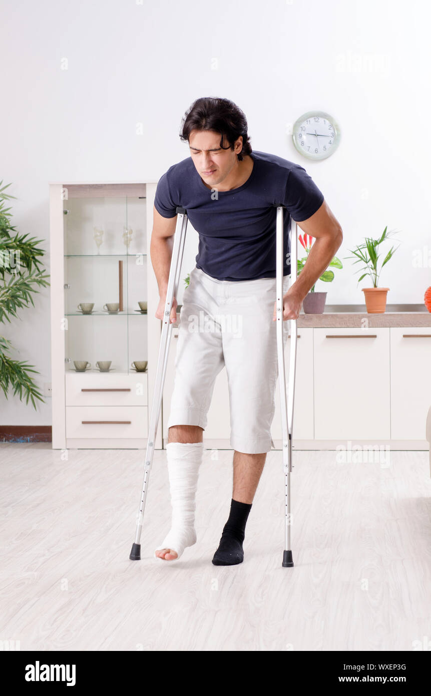 Leg injured young man suffering at home Stock Photo - Alamy