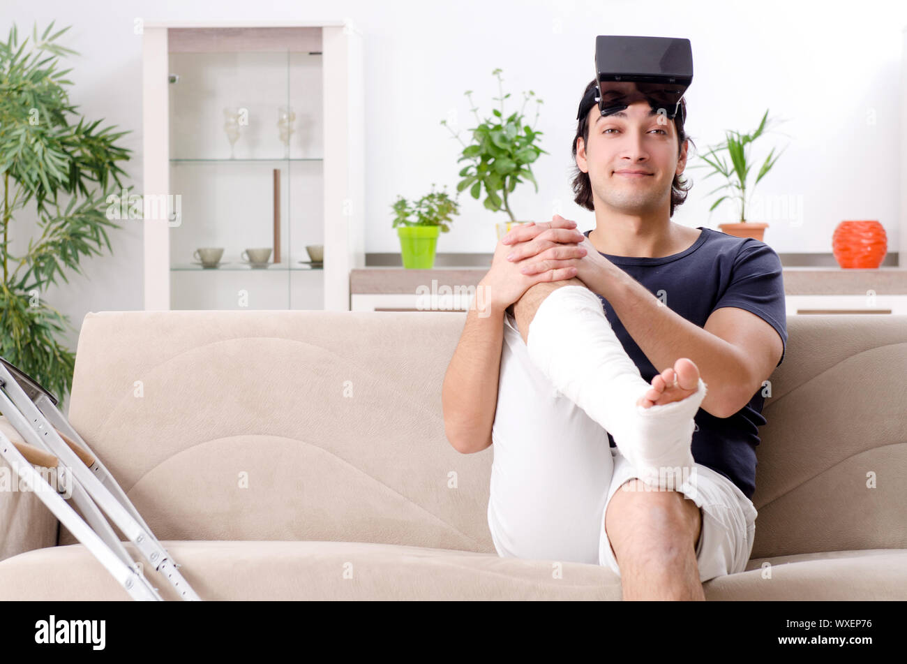 Leg injured young man suffering at home Stock Photo - Alamy