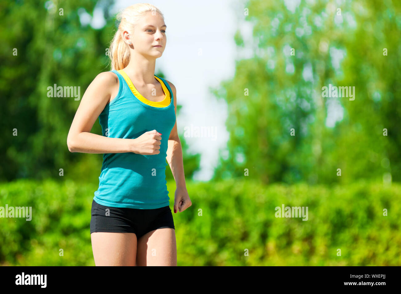 Beautiful young woman running in green park on sunny summer day Stock ...