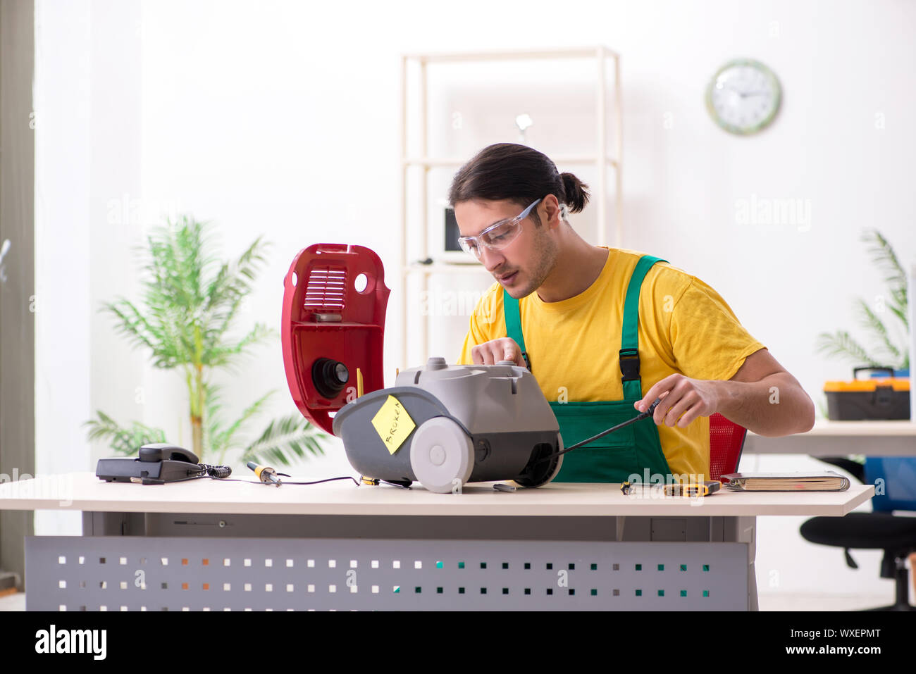 Man repairman repairing vacuum cleaner Stock Photo - Alamy