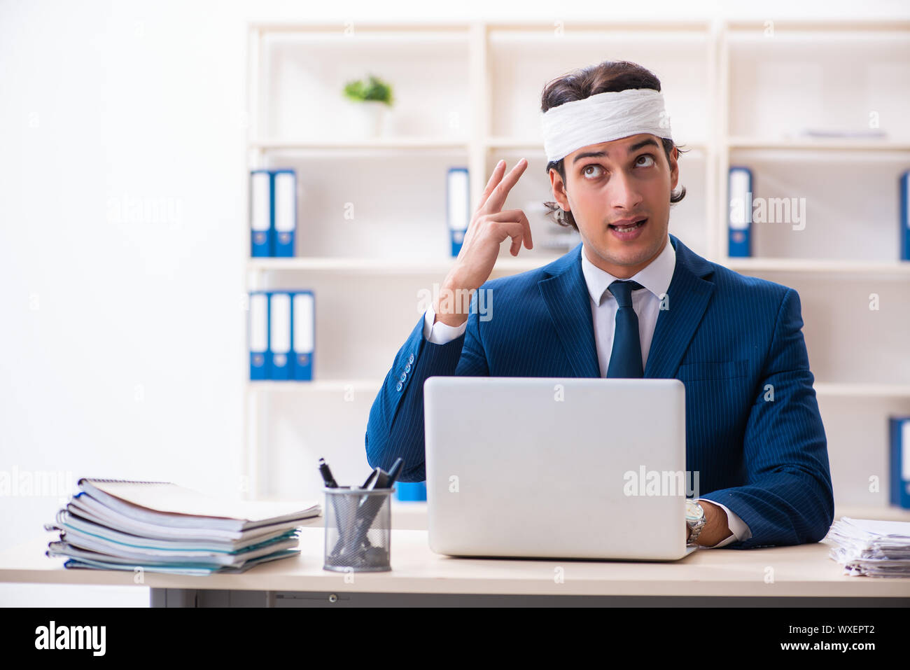 Head injured male employee working in the office Stock Photo - Alamy