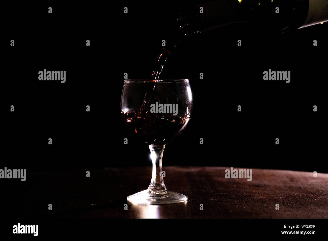 Red wine pouring into a glass close-up .Flowing wine from bottle Stock ...