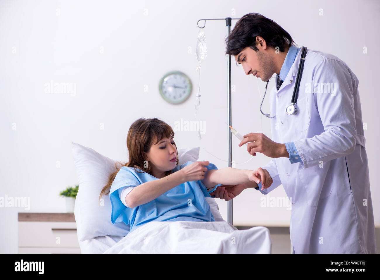 Male doctor visiting female patient in ward Stock Photo - Alamy