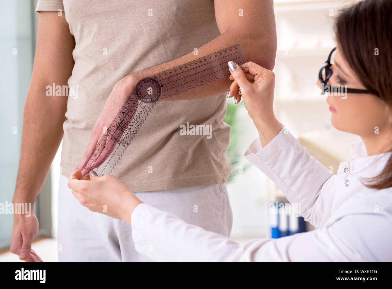 Female doctor checking patient's joint flexibility with goniometer ...