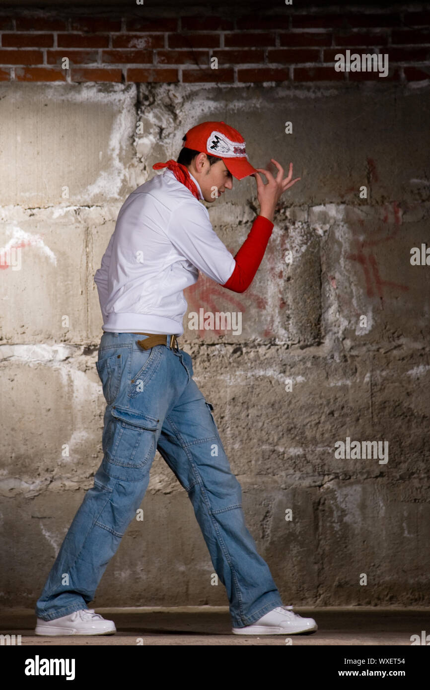 Hip hop men dancing in modern style over grey brick wall Stock Photo ...