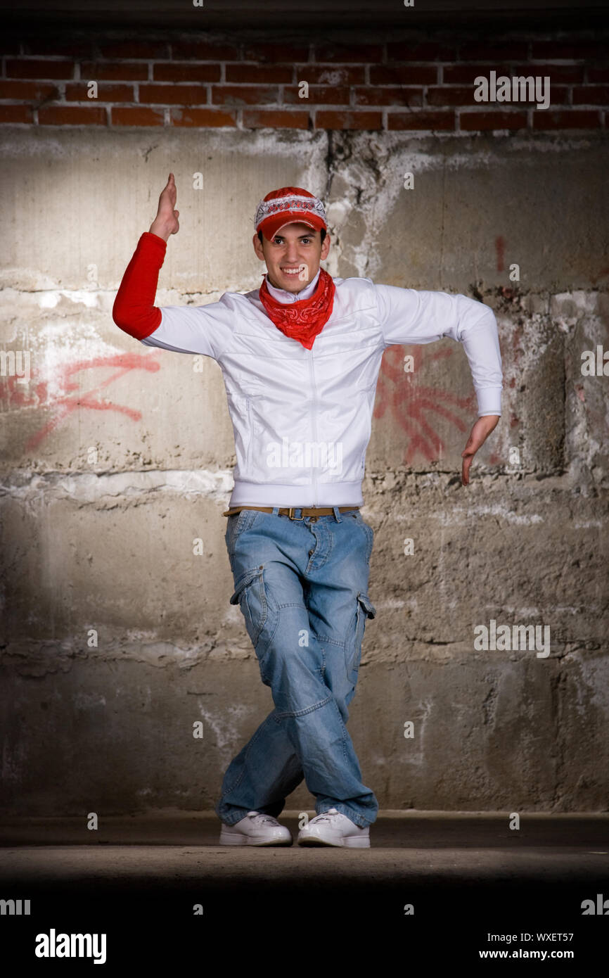 Hip hop men dancing in modern style over grey brick wall Stock Photo ...