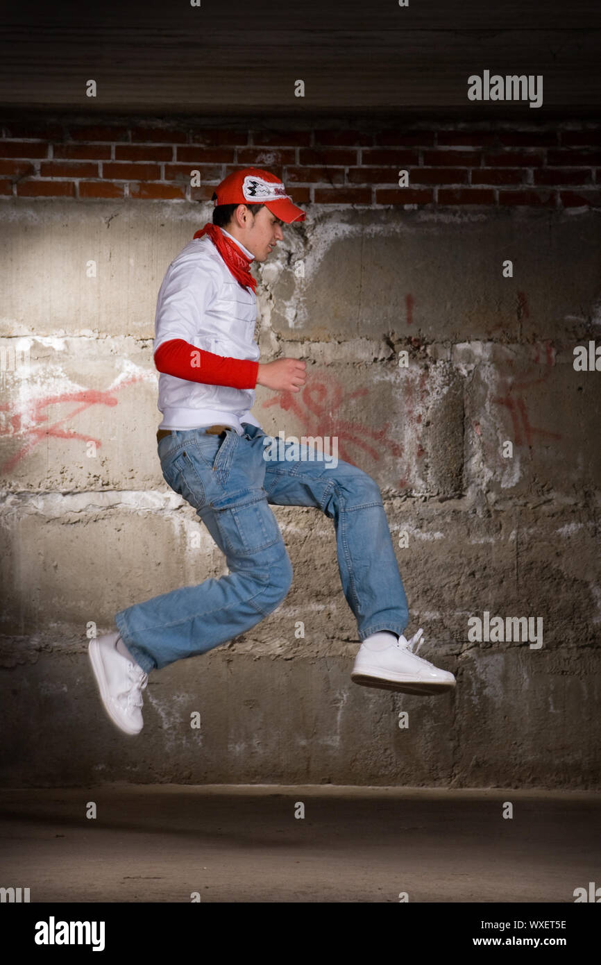 Hip hop men dancing in modern style over grey brick wall Stock Photo ...