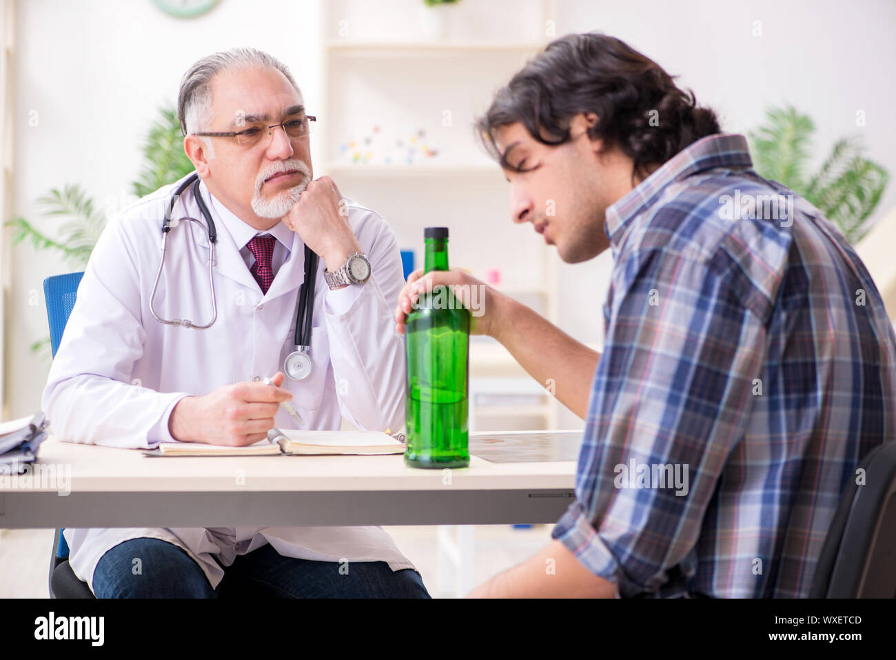 Young male alcoholic visiting old doctor Stock Photo - Alamy
