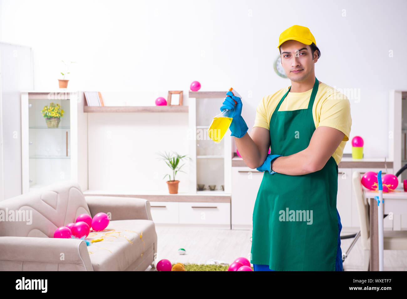 Young male contractor doing housework after party Stock Photo - Alamy
