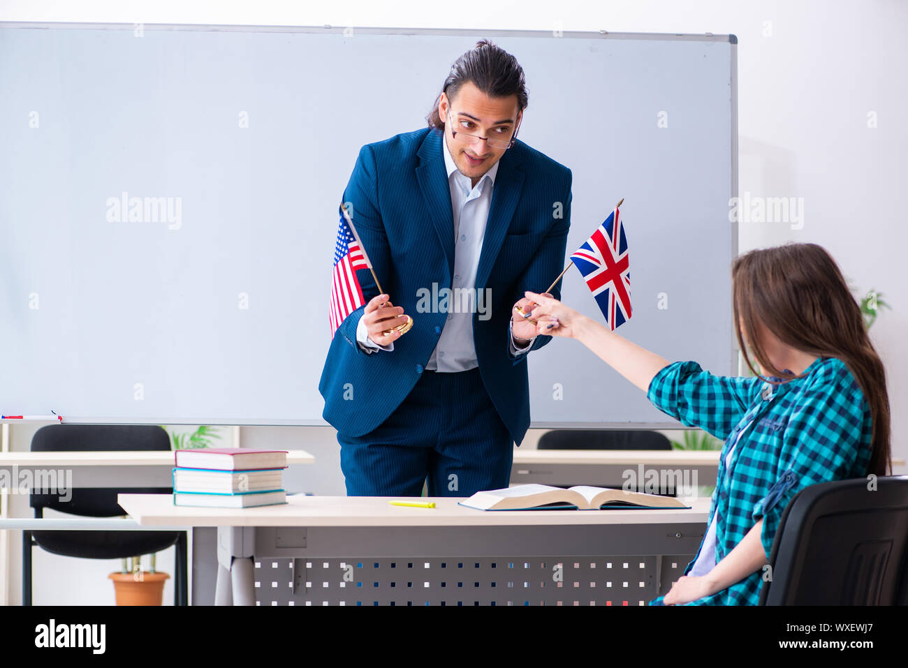 Male english teacher and female student in the classroom Stock Photo ...