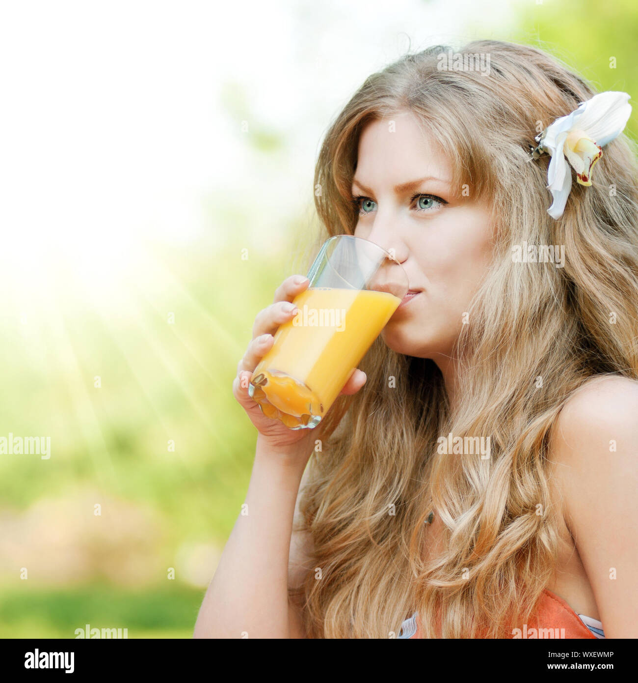 Young happy smiling woman drinking orange juice outdoor Stock Photo - Alamy