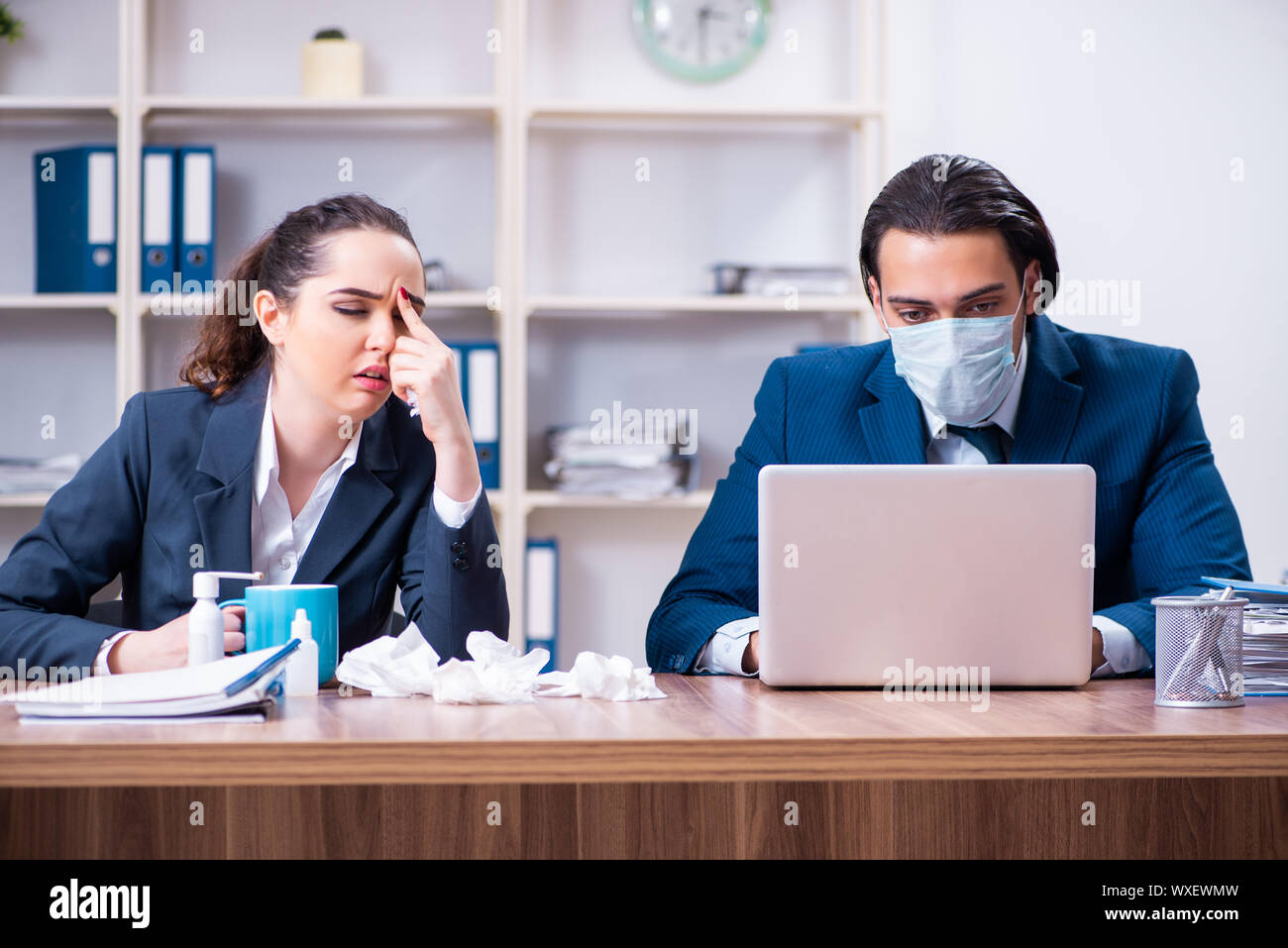 Two employees suffering at workplace Stock Photo - Alamy