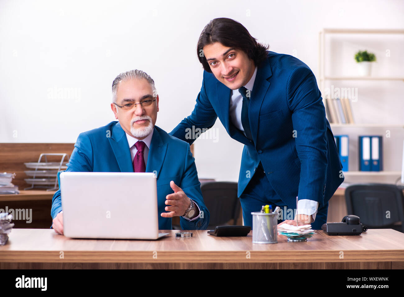 Young and old employees working together in the office Stock Photo - Alamy