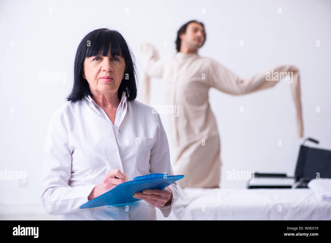 Old female psychiatrist visiting young male patient Stock Photo - Alamy