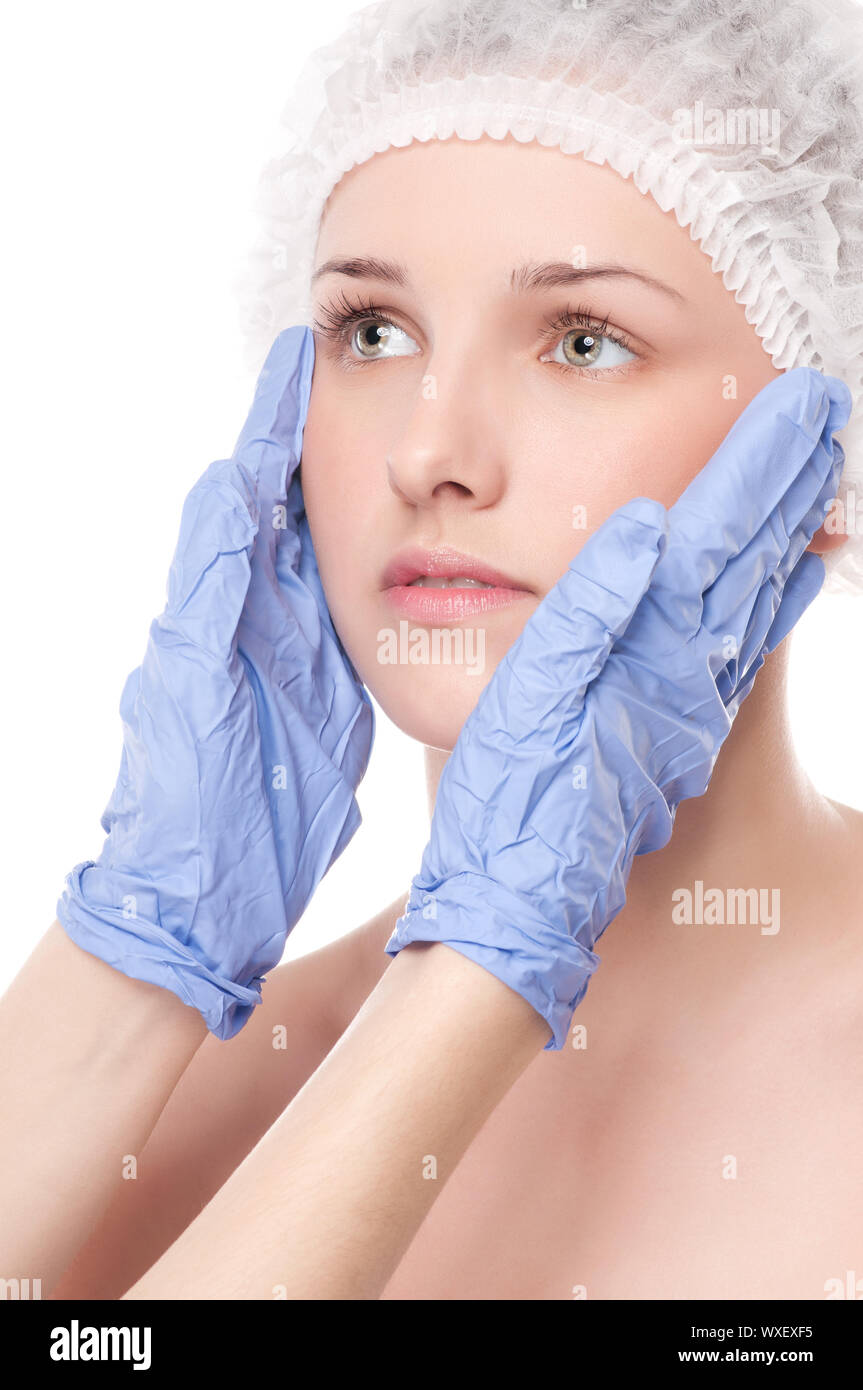 Medical face examination of beautiful woman by hands in glove - close ...
