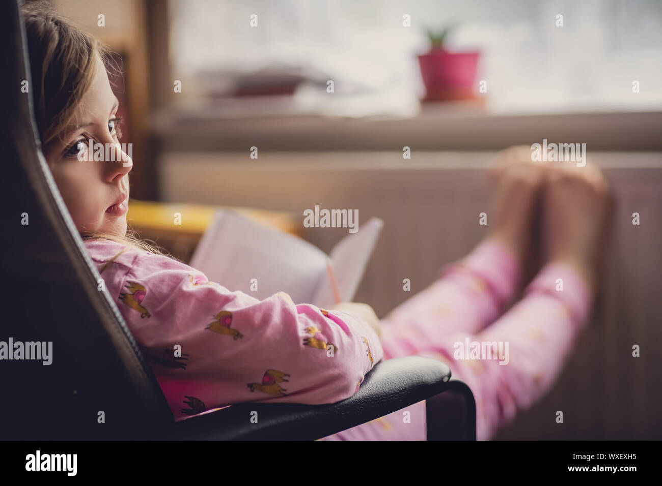 Girl in pyjama reading a book Stock Photo - Alamy